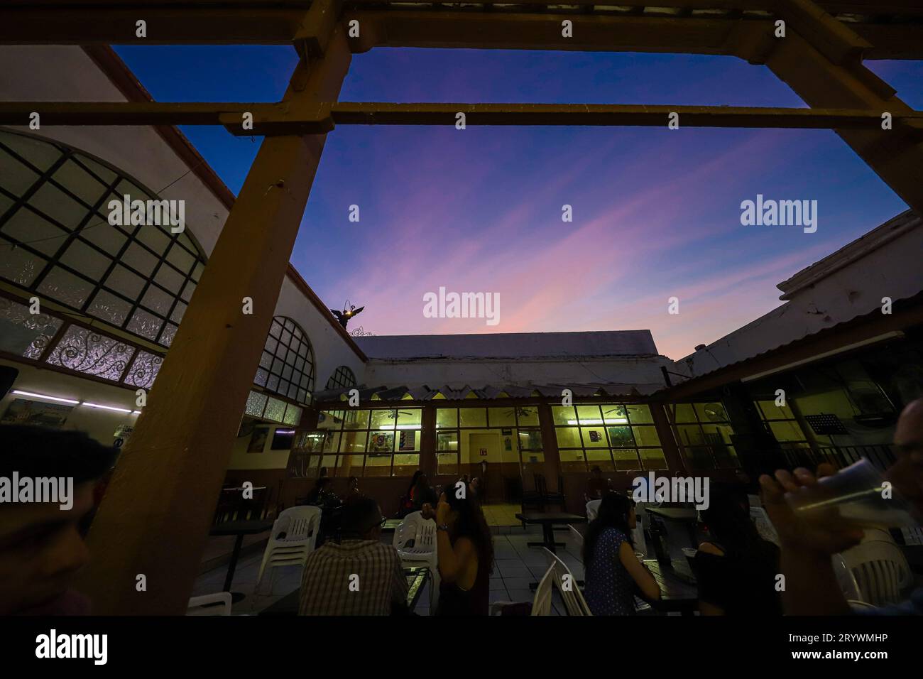 Purple and pink colored sky at dusk seen on the patio and roof of the ...