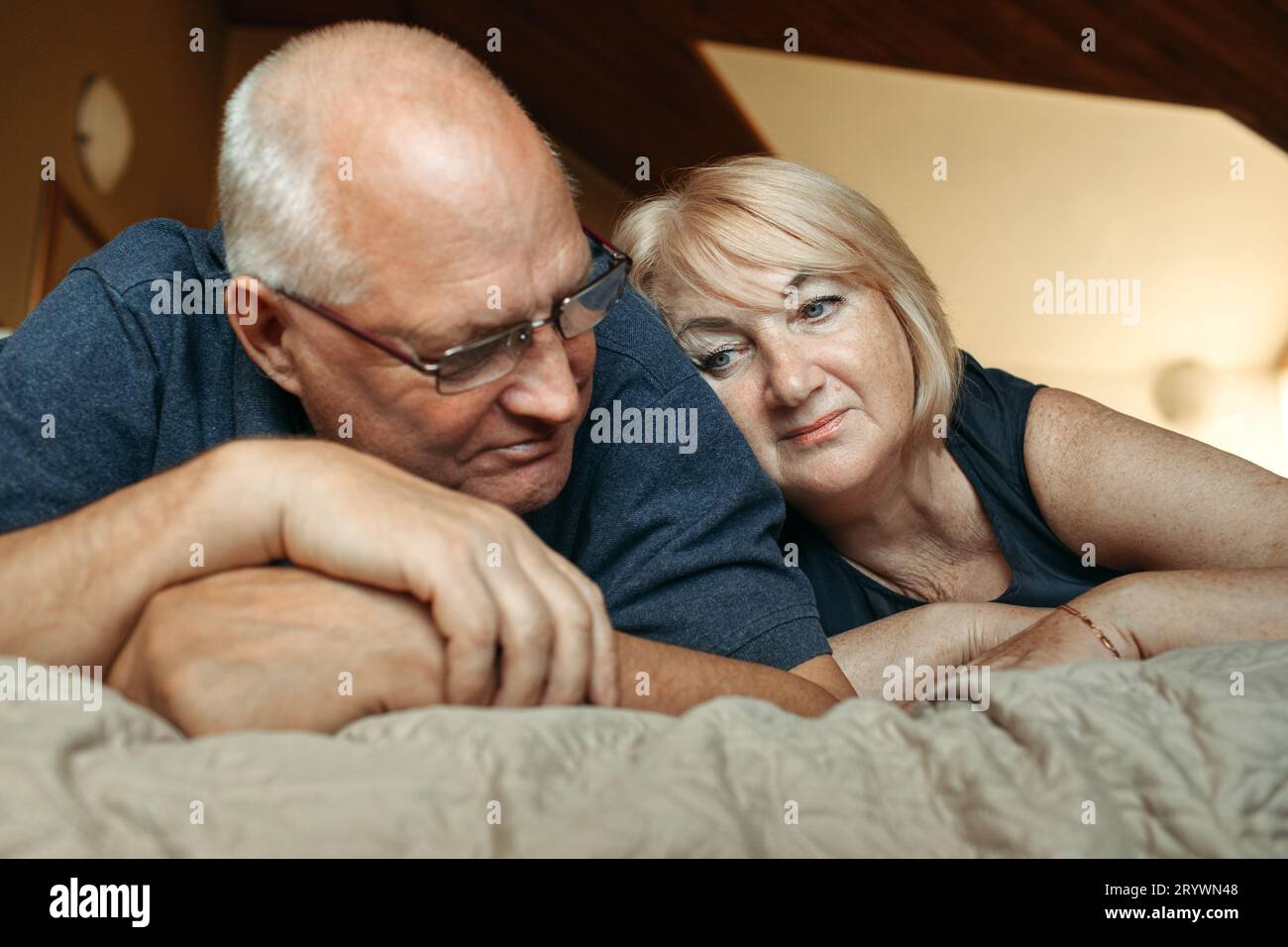 Elderly couple lies on bed hi-res stock photography and images - Alamy