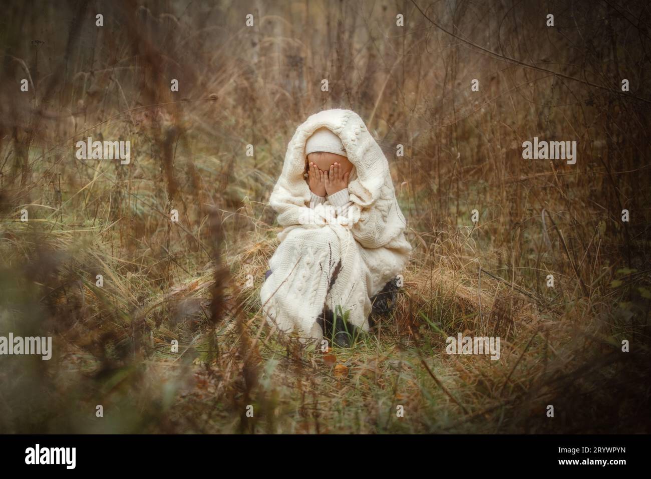 A girl sits alone in the autumn forest, she has closed her eyes - she ...