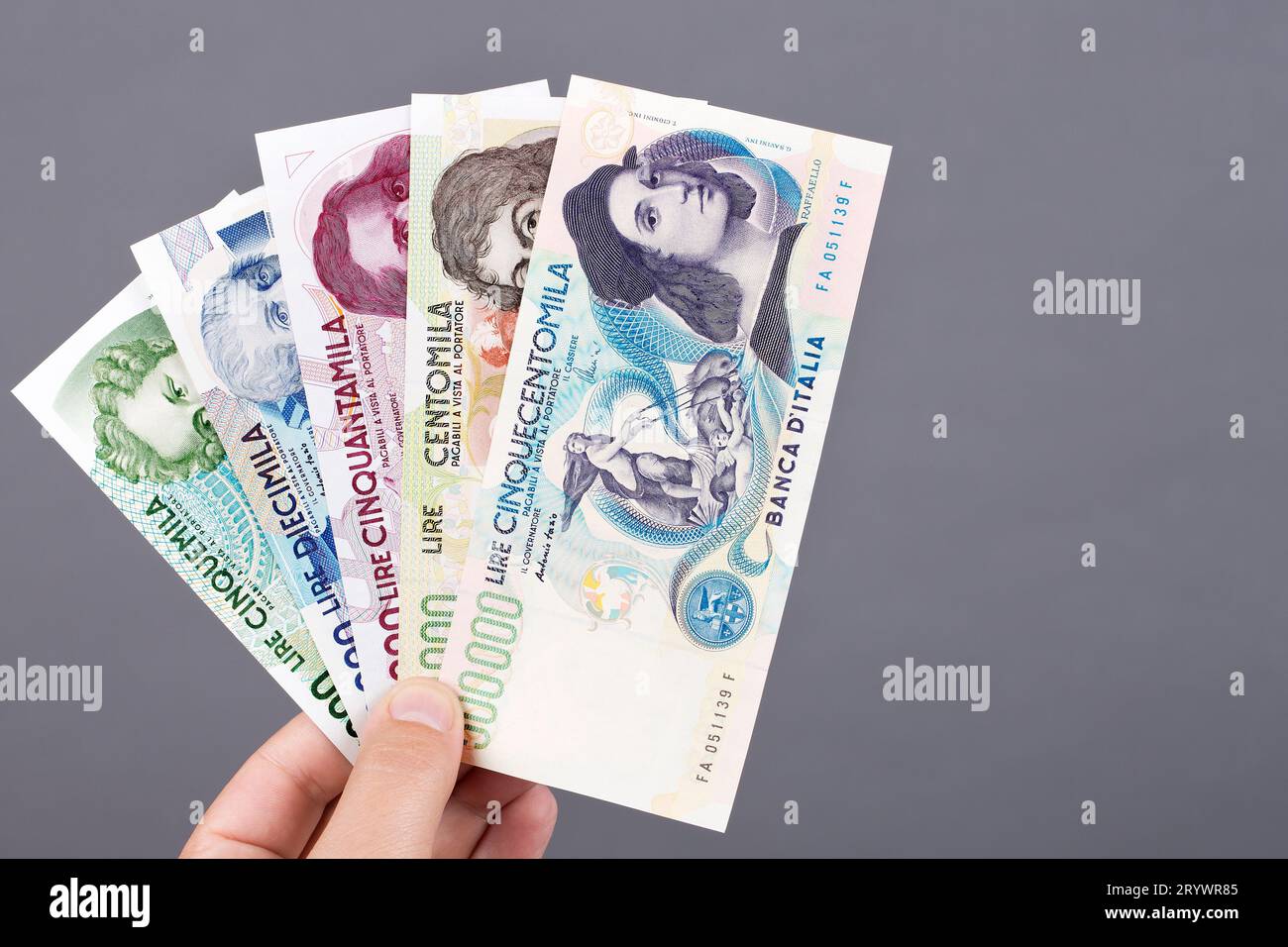 Italian money in the hand on a gray background Stock Photo - Alamy