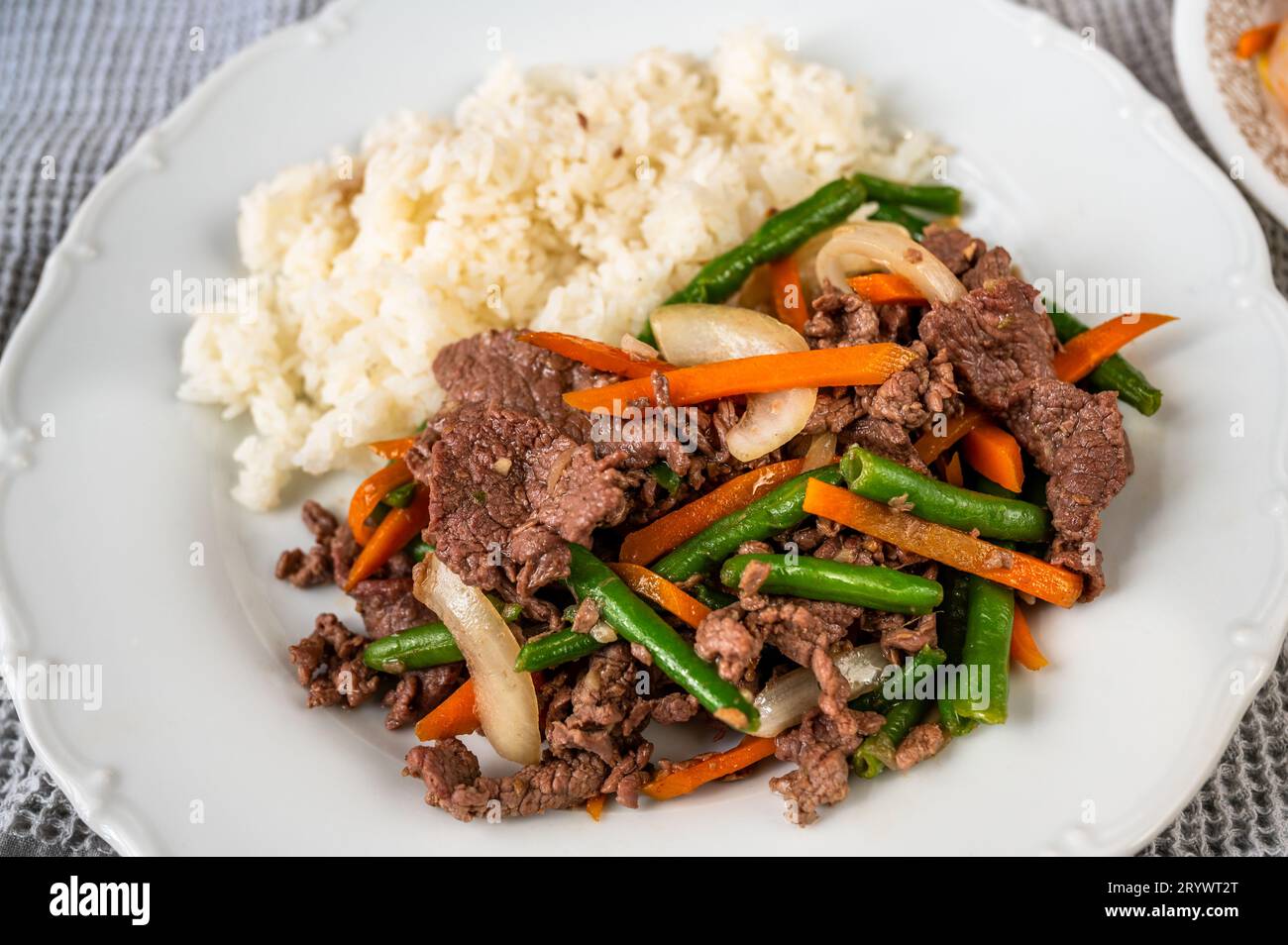 Sliced beef with green beans, onion and carrot and white rice ...