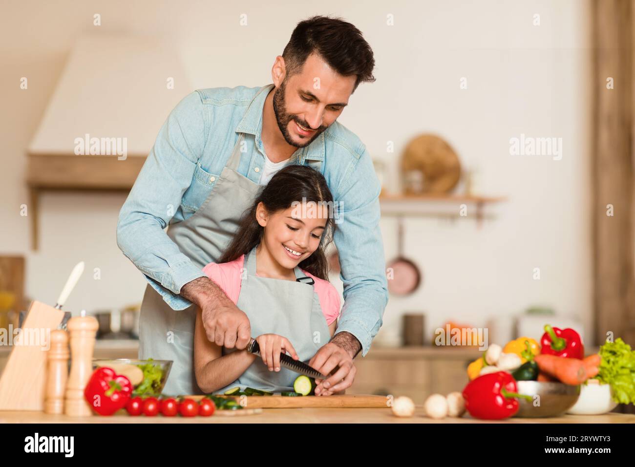 Cooking with dad. Happy girl preparing dinner with her father in ...