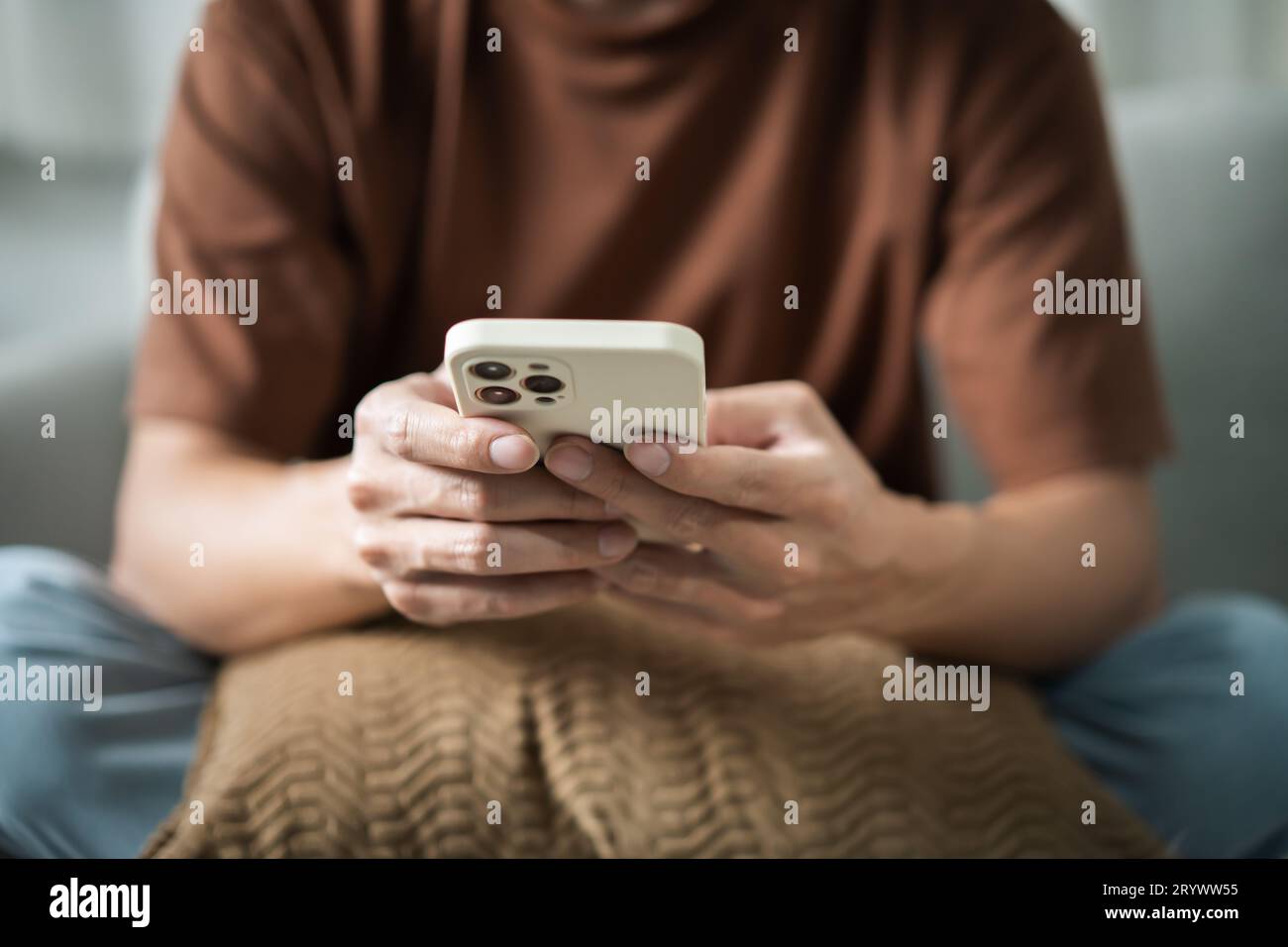 Relaxed young asian man using smart phone spending time checking news ...