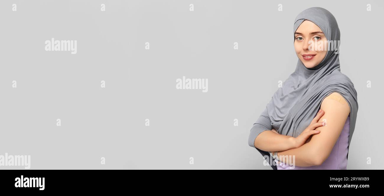 Muslim woman with medical patch on arm against grey background with ...