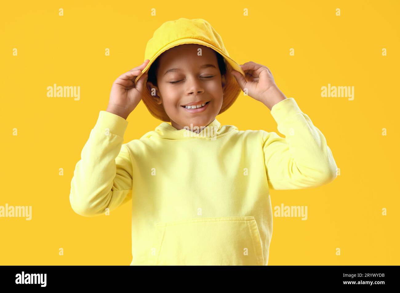 African-American little boy in bucket hat on yellow background Stock ...