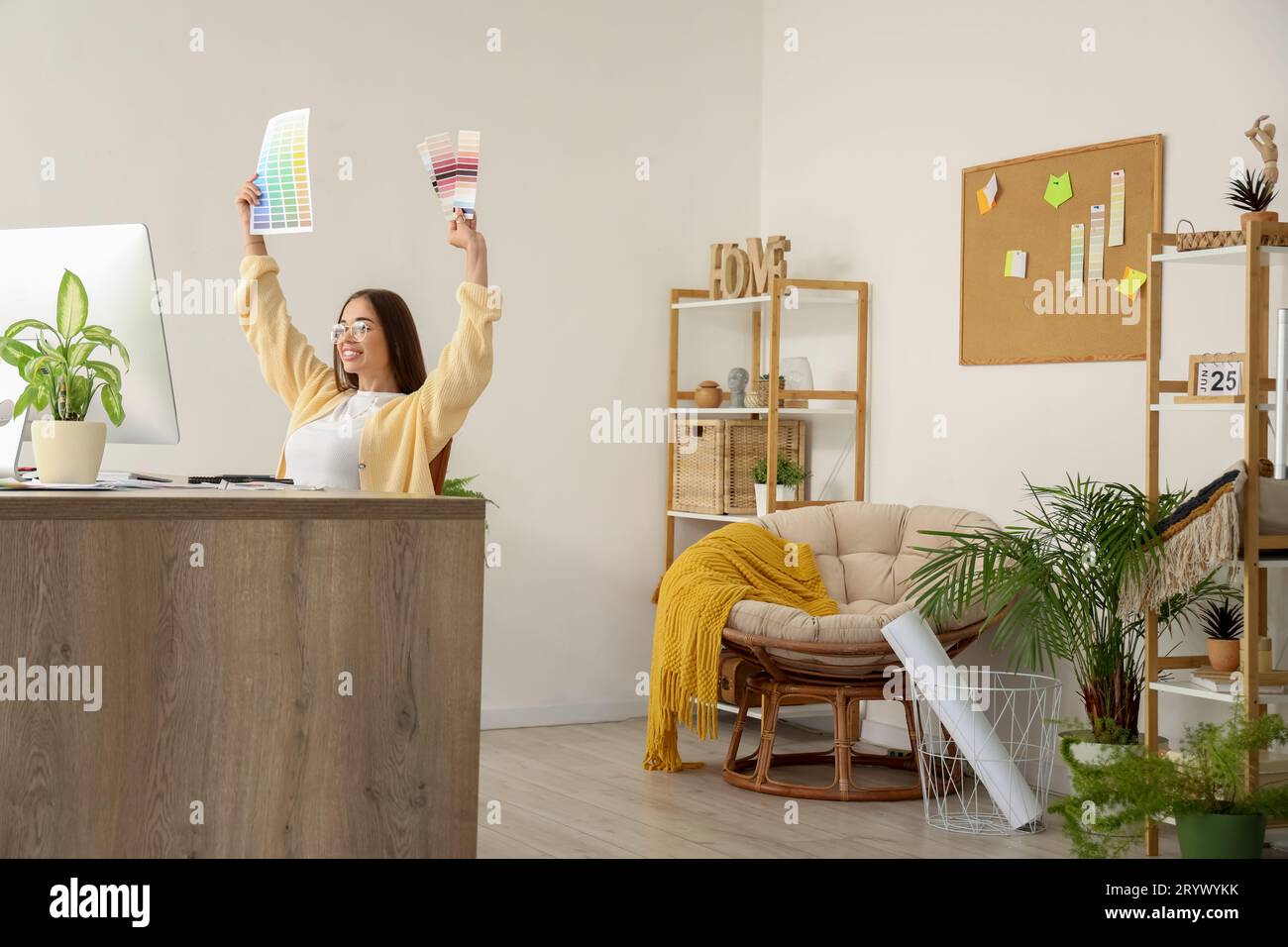 Female interior designer working with color palettes at table in office ...
