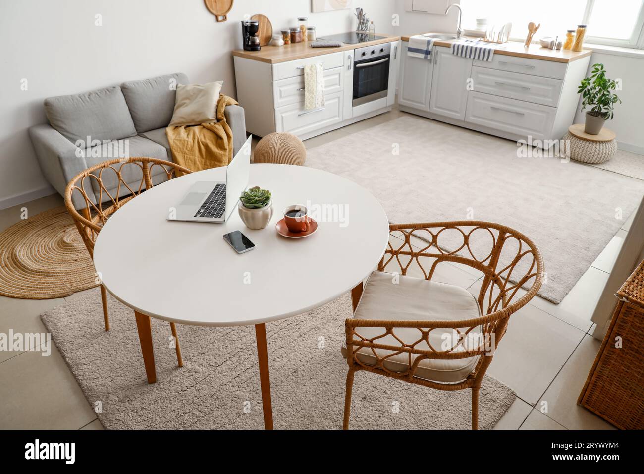 Interior of light kitchen with dining table, counters and soft carpets ...