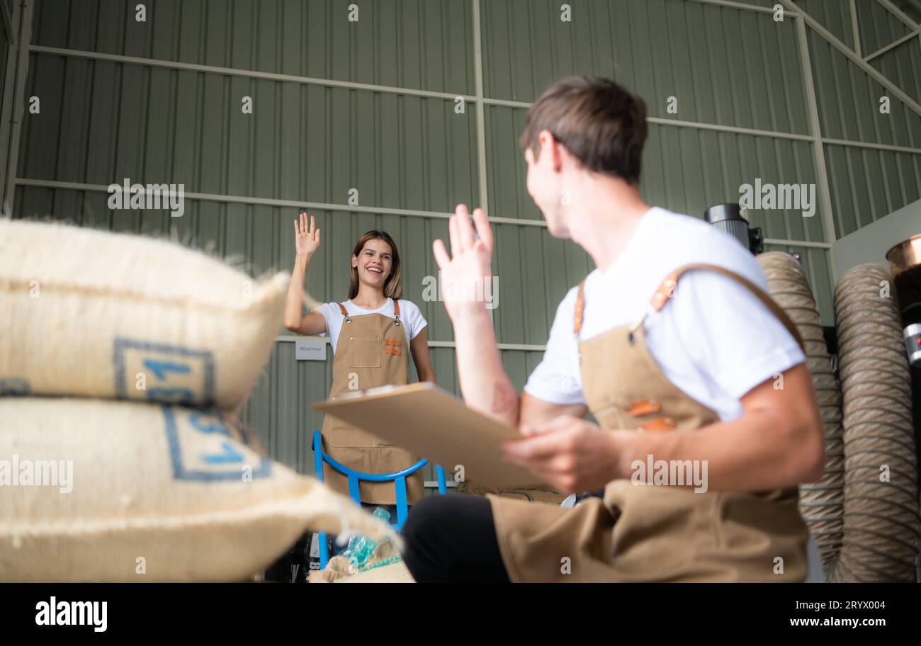Portrait of a young male worker in overalls working checking coffee ...