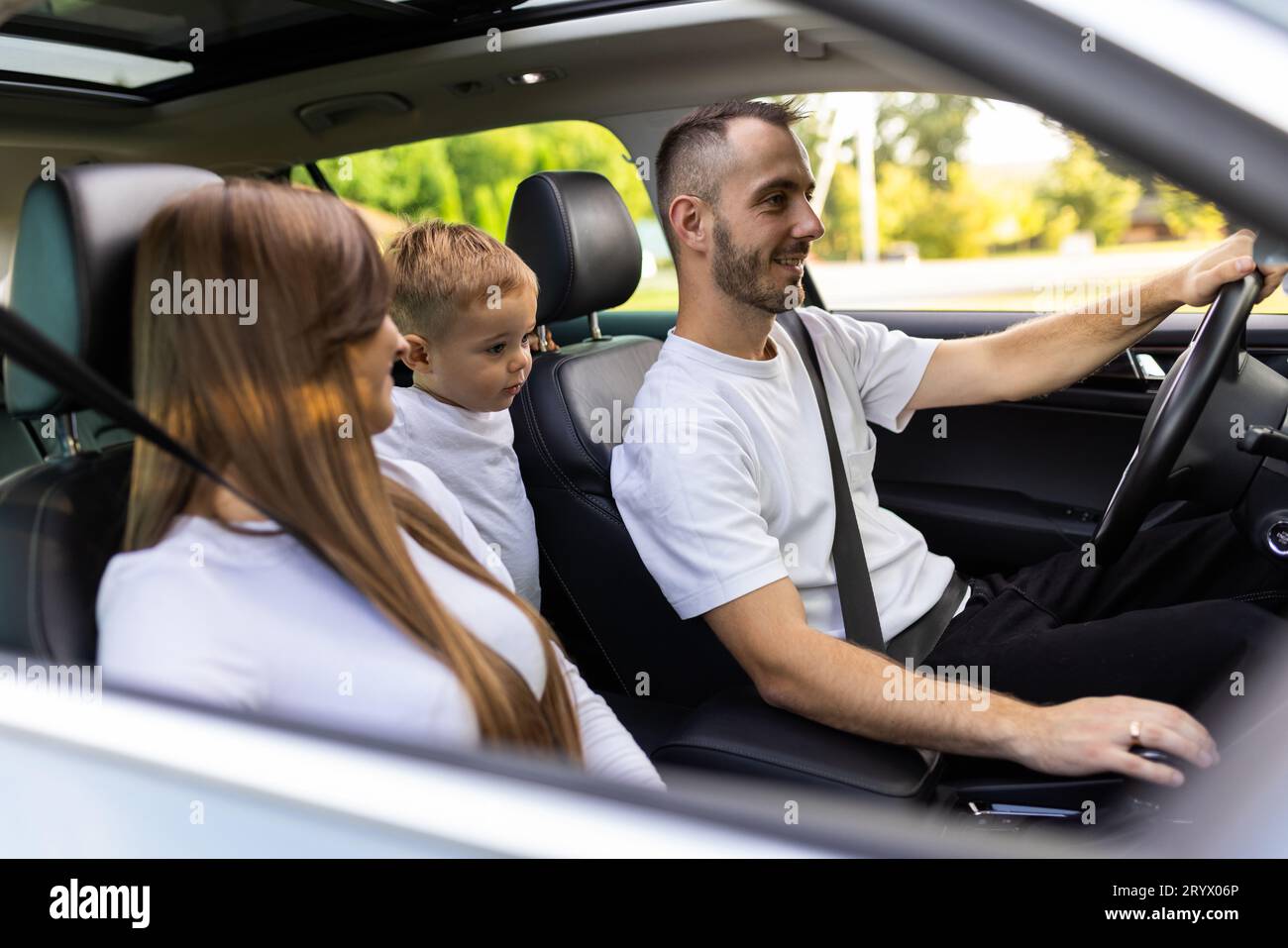 Cheerful young traditional family has a long auto journey and singing ...