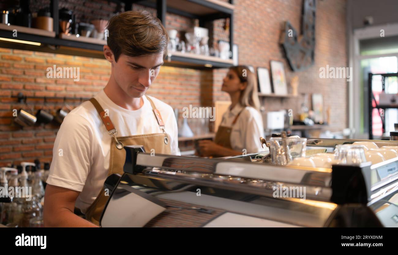 Barista working in cafe. Portrait of young male barista standing behind ...