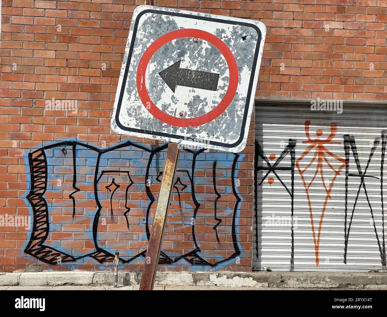 Sign with Old Left Turn Only Sign and Graffiti on Brick Wall and ...
