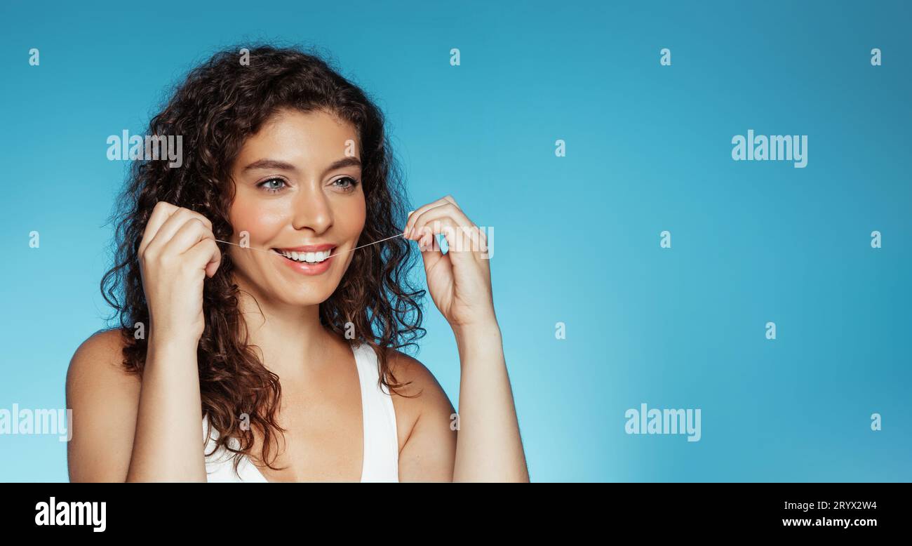 Cheerful millennial european curly lady brushing teeth with dental ...