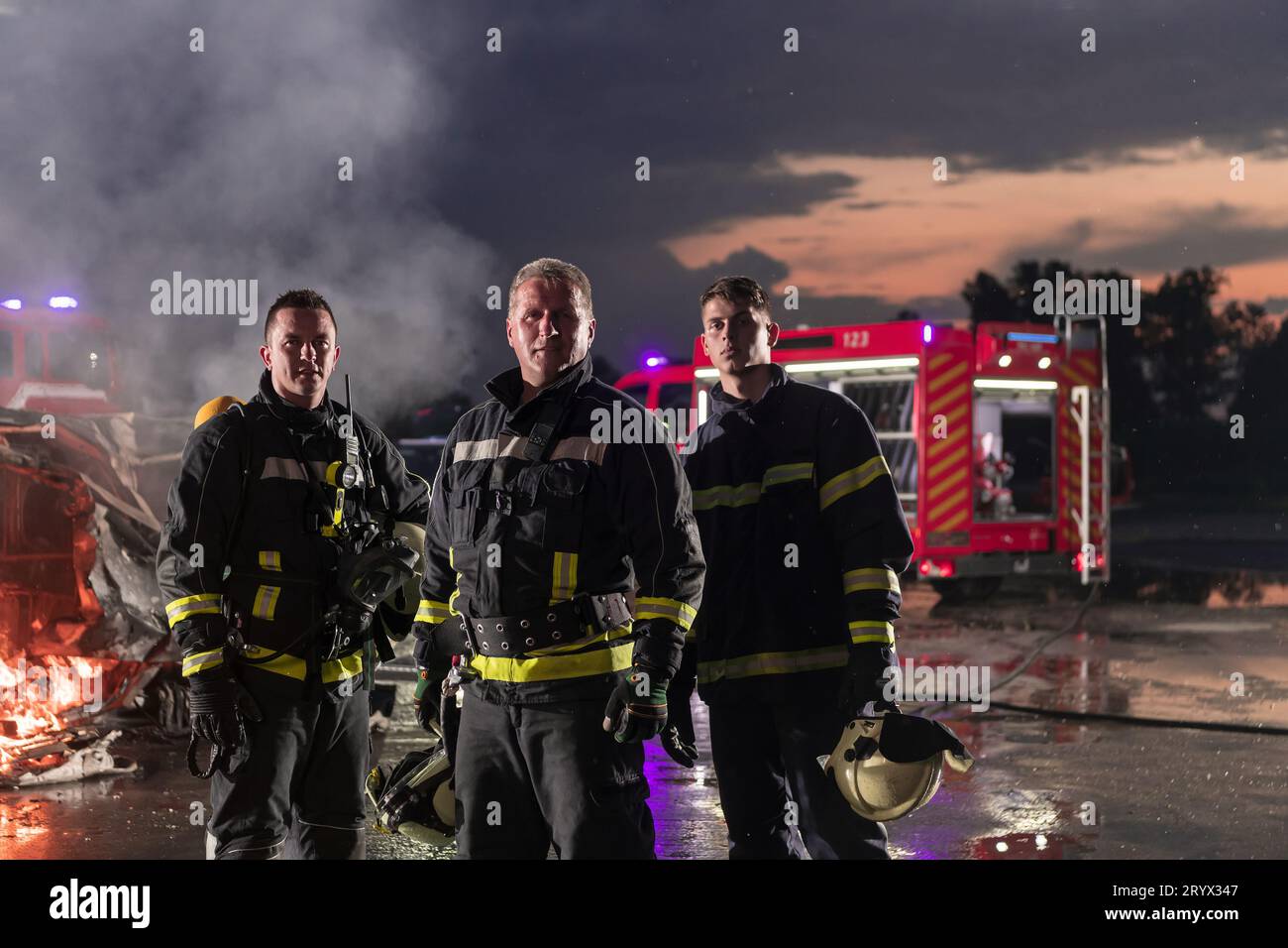 Brave Firefighters Team Walking to the Camera. In Background Paramedics ...