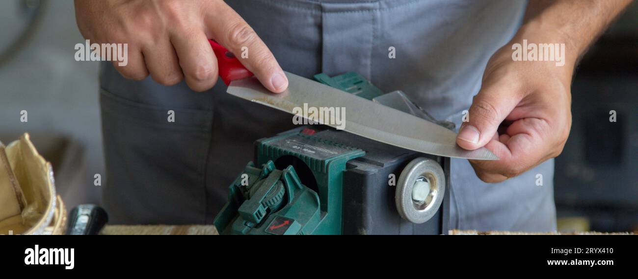 Image of a shoemaker sharpening a kitchen knife with a sharpening wheel ...