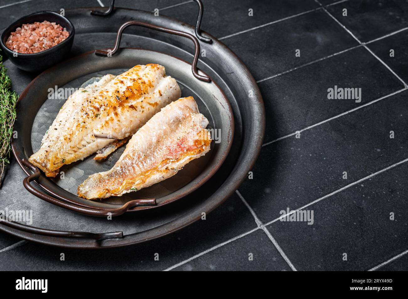 Roasted ocean red perch fillet with olive oil, thyme and spices. Black ...