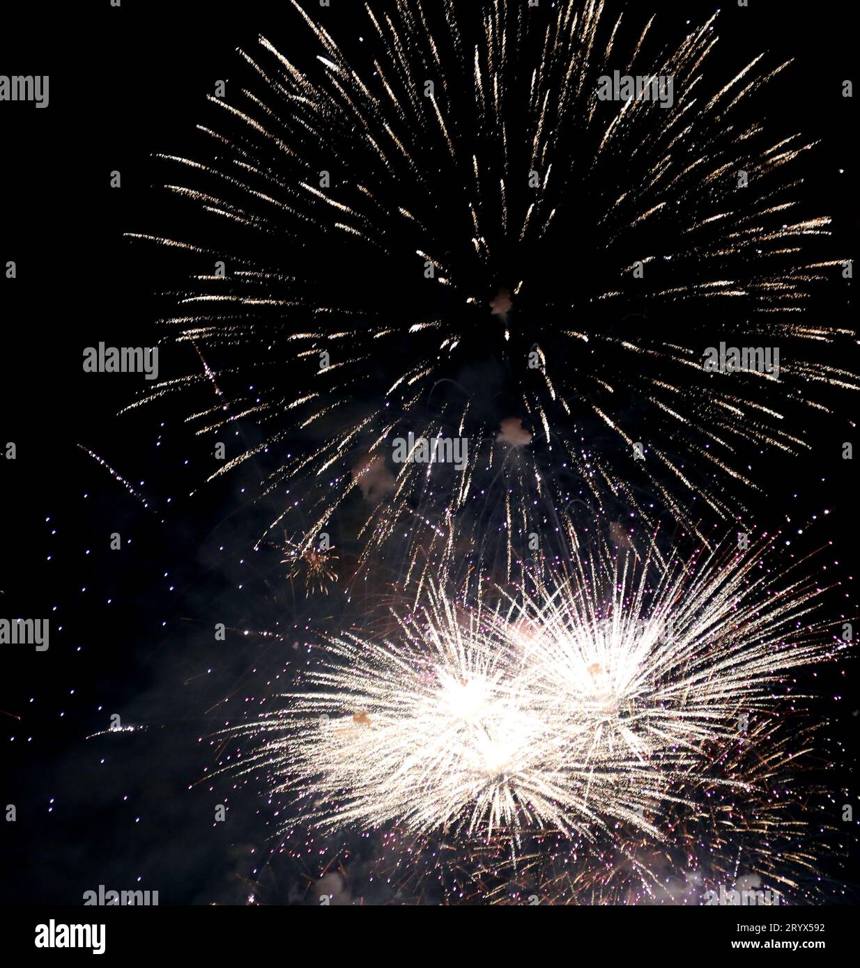 explosions and sparks of white color fireworks in the dark night during ...
