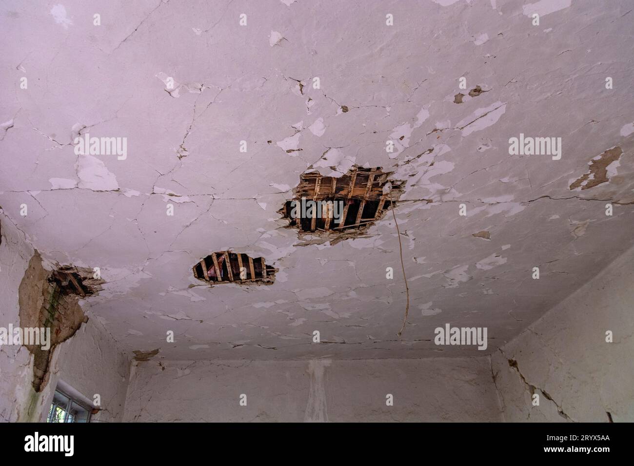 The interior ceiling of an ancient building, riddled with large holes ...