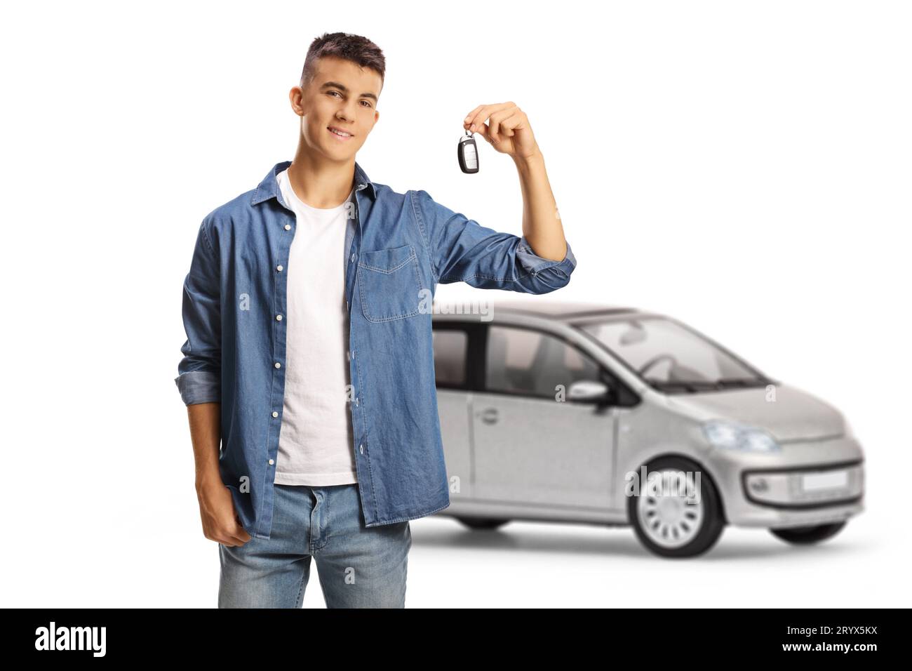 Male teenage guy holding a car key and standing in front of a silver ...