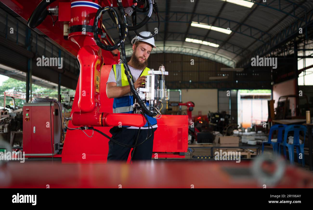 An engineers installing and testing a large robotic arm. before sending ...