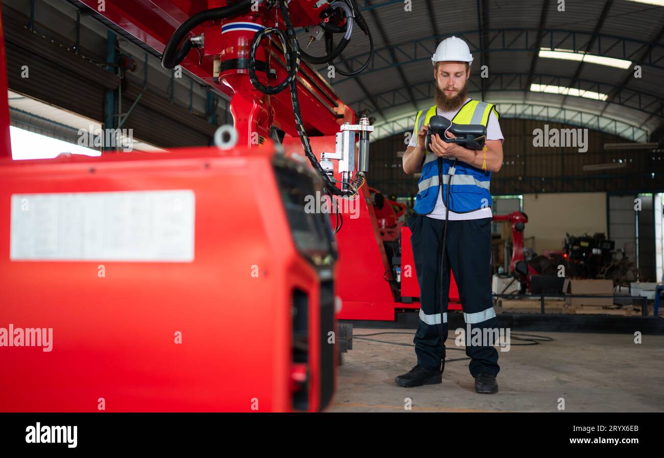 An engineers installing and testing a large robotic arm. before sending ...