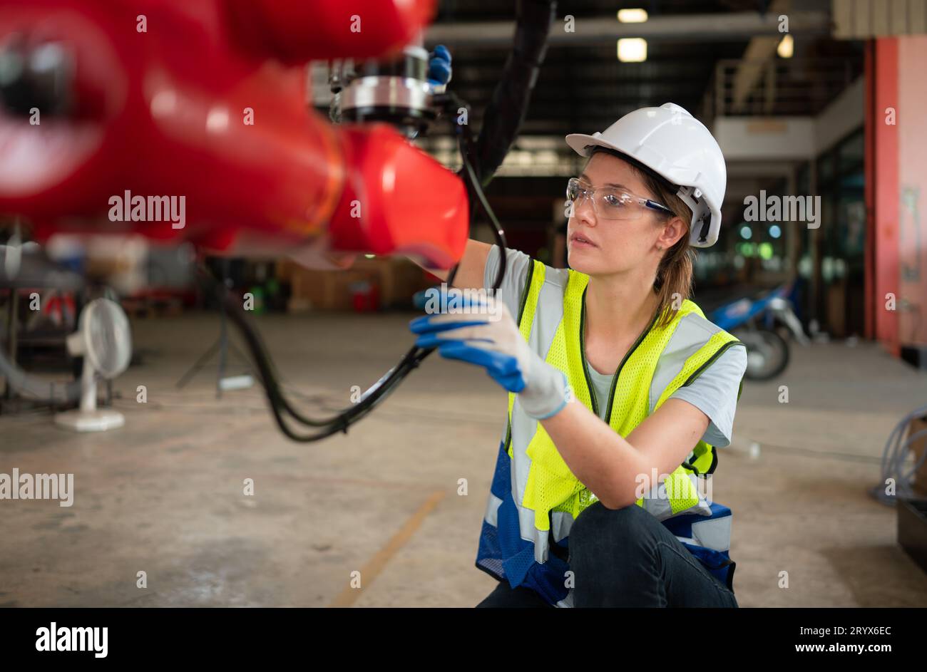 An engineers installing and testing a large robotic arm. before sending ...