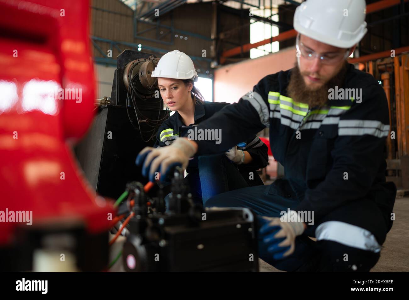 Both of engineers installing a small robotic arm is being installed for ... Both of engineers installing a small robotic arm is being installed for ...