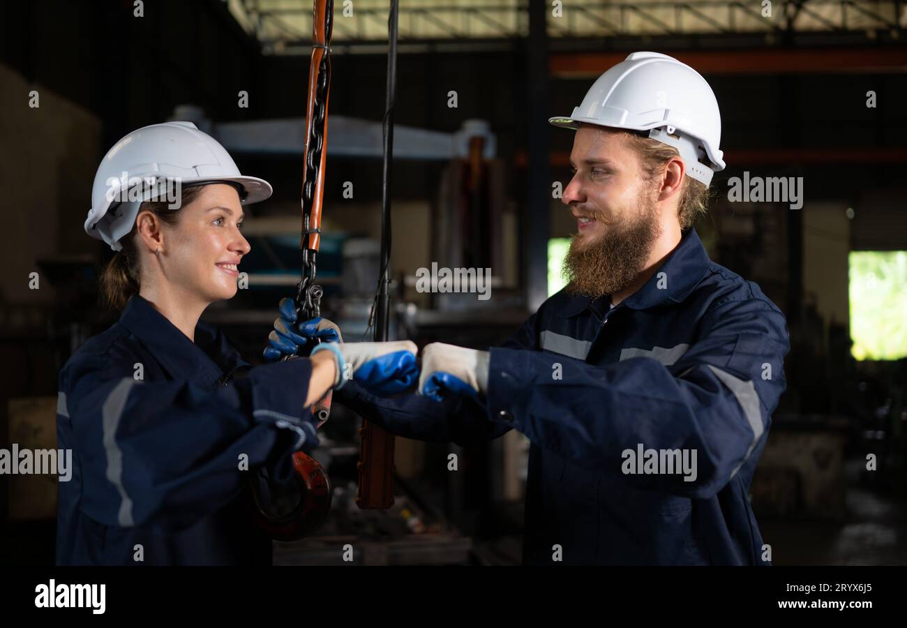 Two technicians inspecting and testing the operation of lifting cranes ...