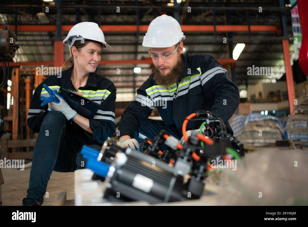 Both of engineers installing a small robotic arm is being installed for ... Both of engineers installing a small robotic arm is being installed for ...