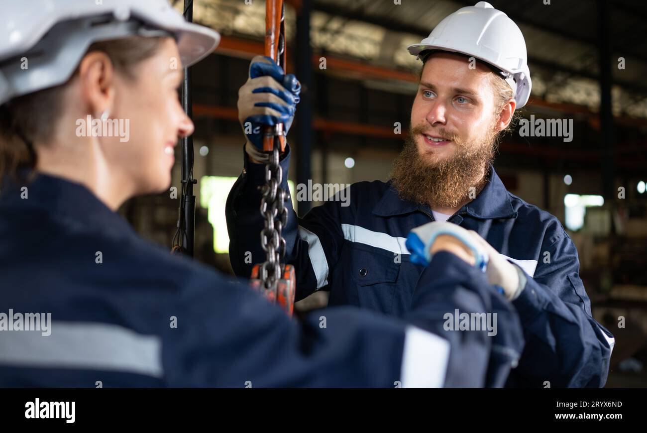 Two technicians inspecting and testing the operation of lifting cranes ...
