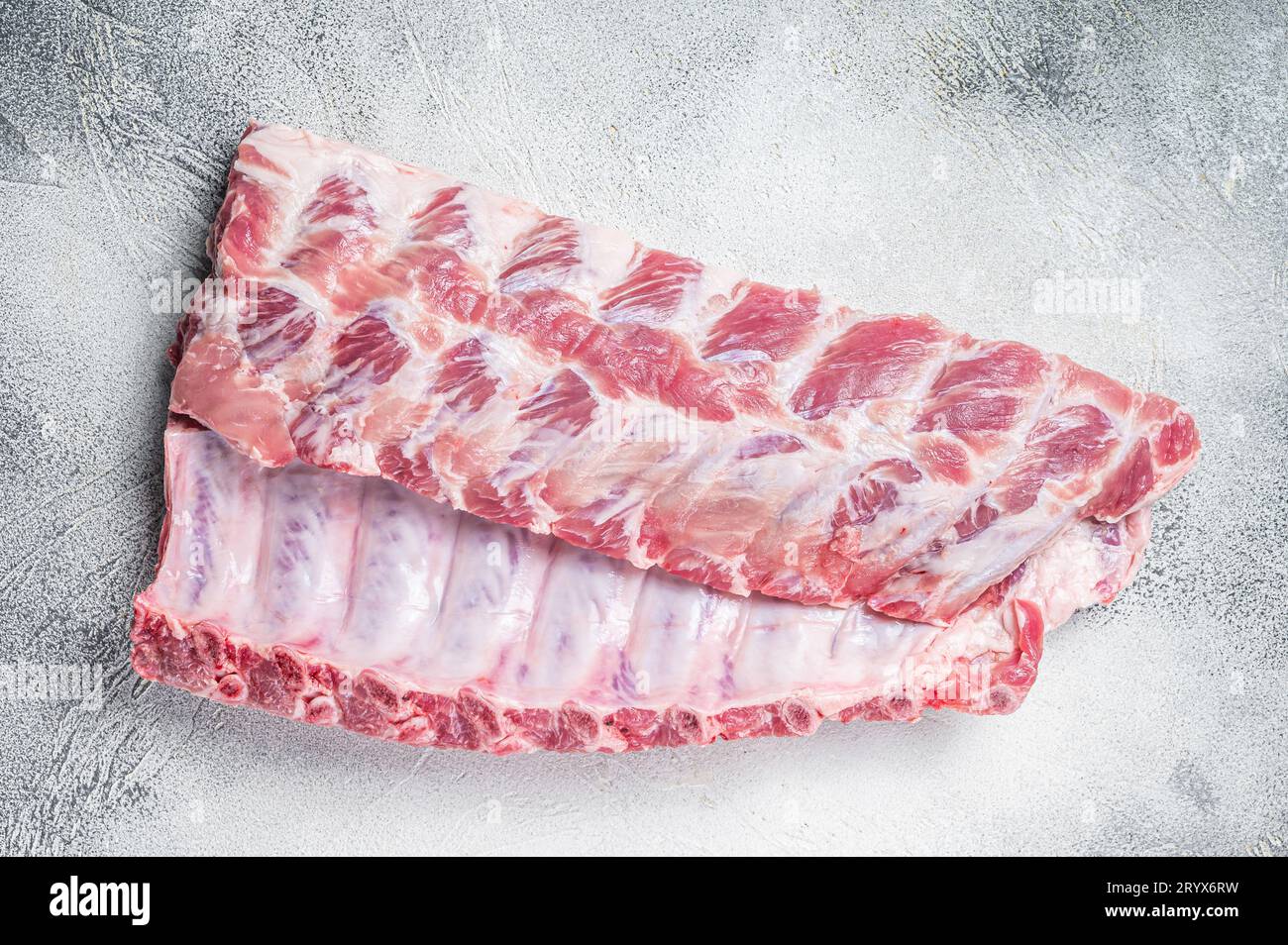 Raw rack of pork spare ribs. White background. Top view. Copy space ...