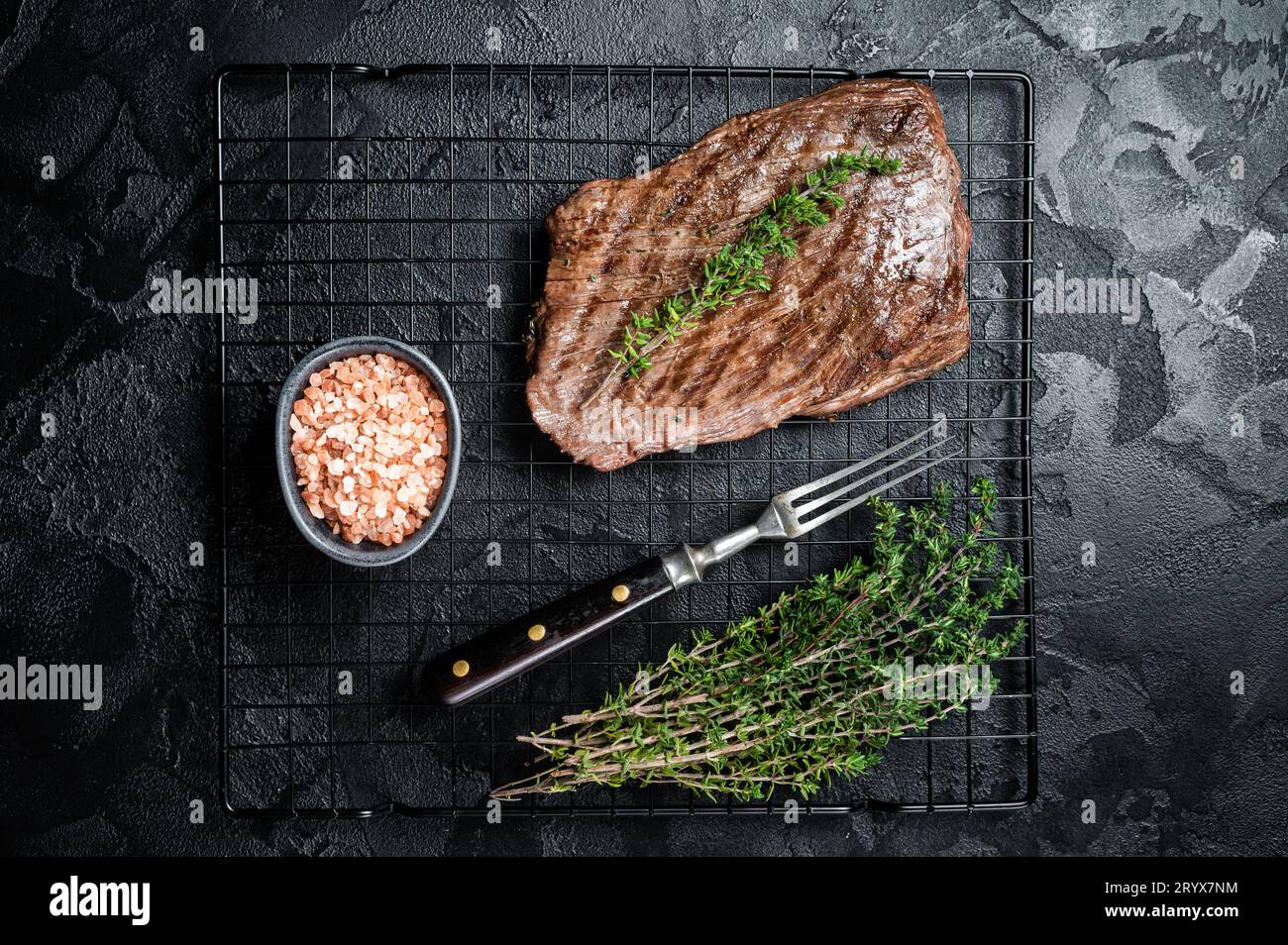 Roasted medium rare flank beef steak with thyme. Black background. Top ...