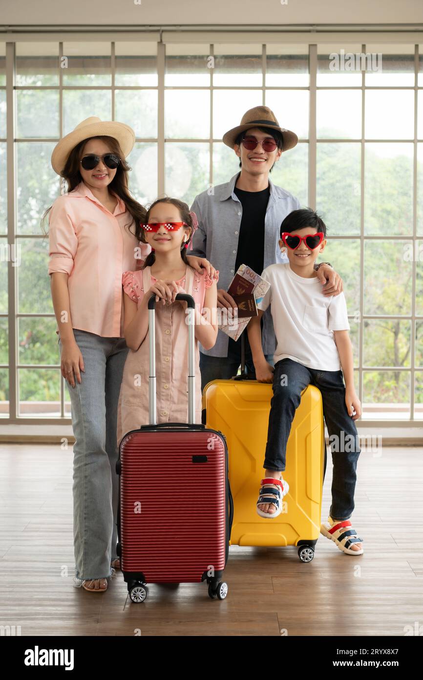 Father, mother, son and daughter packing for a weekend trip and ready ...