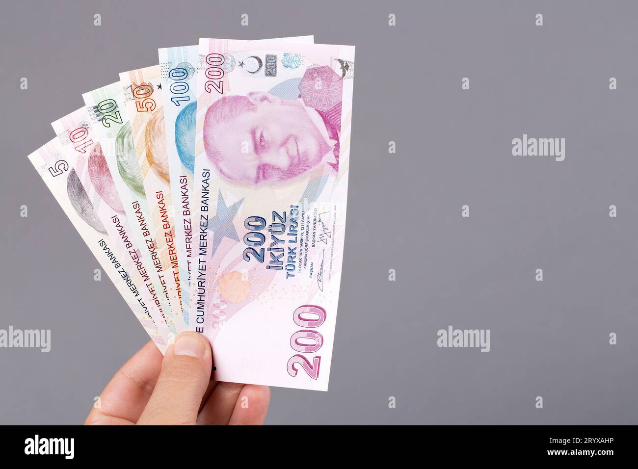 Turkish lira in the hand on a gray background Stock Photo - Alamy