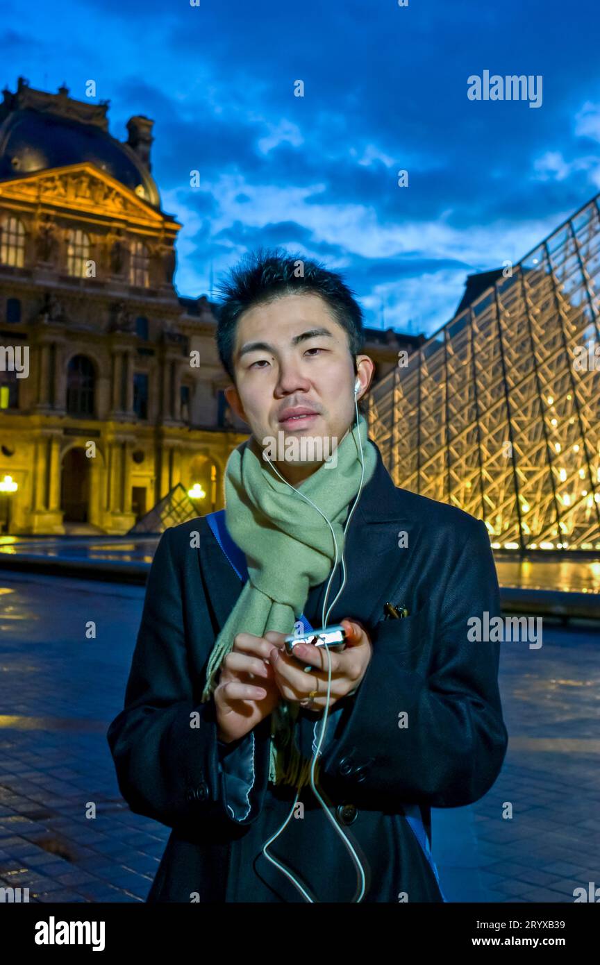 Portrait Young Asian Man Listening to I-pod Music Device Outside at ...