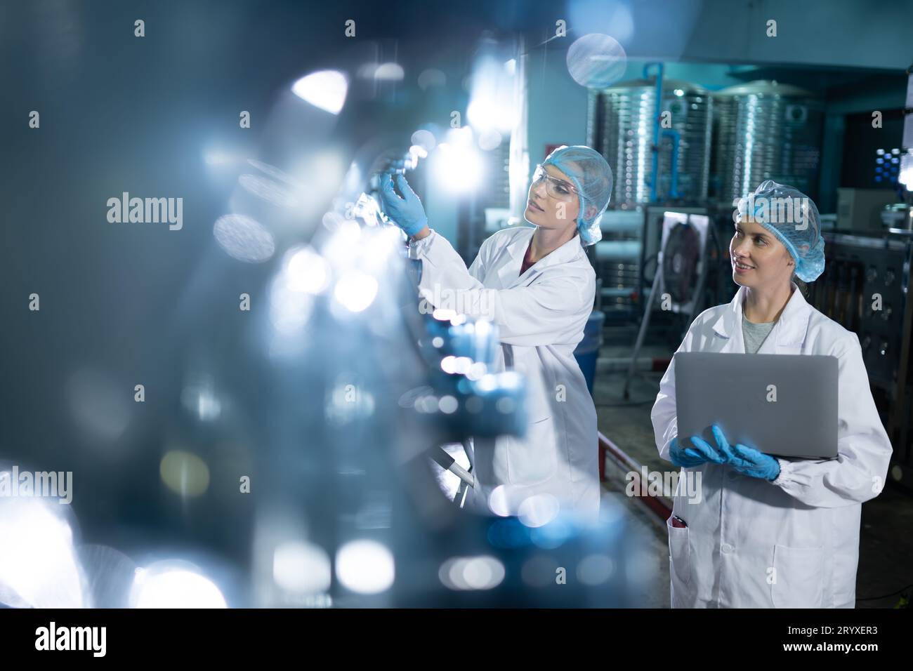 Portrait of a scientist in the drinking water factory using a ladder ...