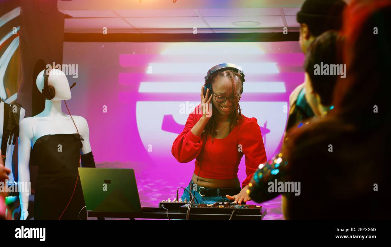 Happy DJ woman mixing sounds on station, wearing headset and using ...