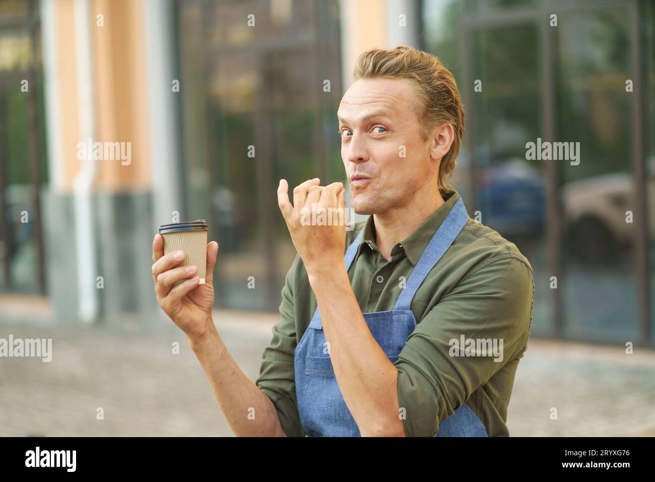 Waiter presenting delicious and tasty cup of coffee in paper cup to-go ...