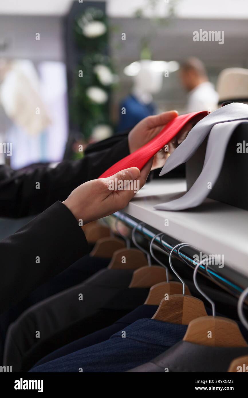 Clothing store woman seller hands touching red tie on shelf while ...