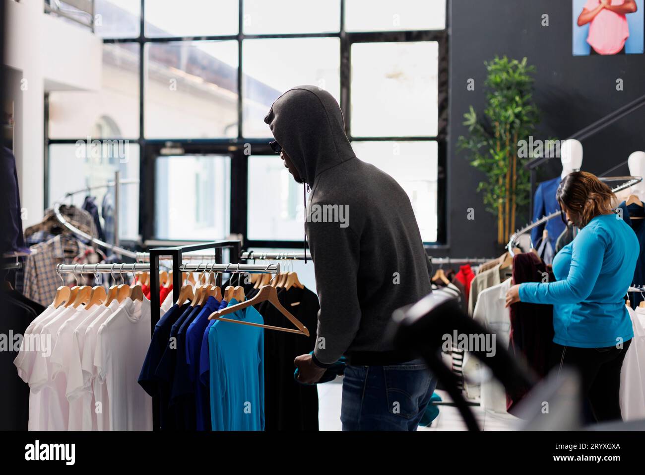 Woman stealing clothes from store hi-res stock photography and images ...