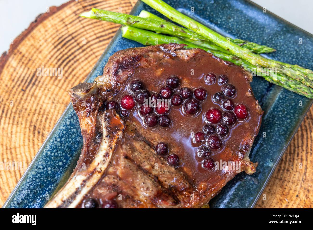 Grilled bone in ribeye served with potatoes and asparragus topped with ...