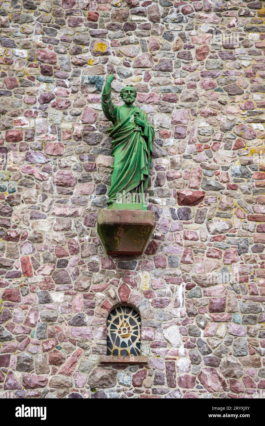 Green St. Pierre statue on cathedral wall in St. Pierre, France Stock ...