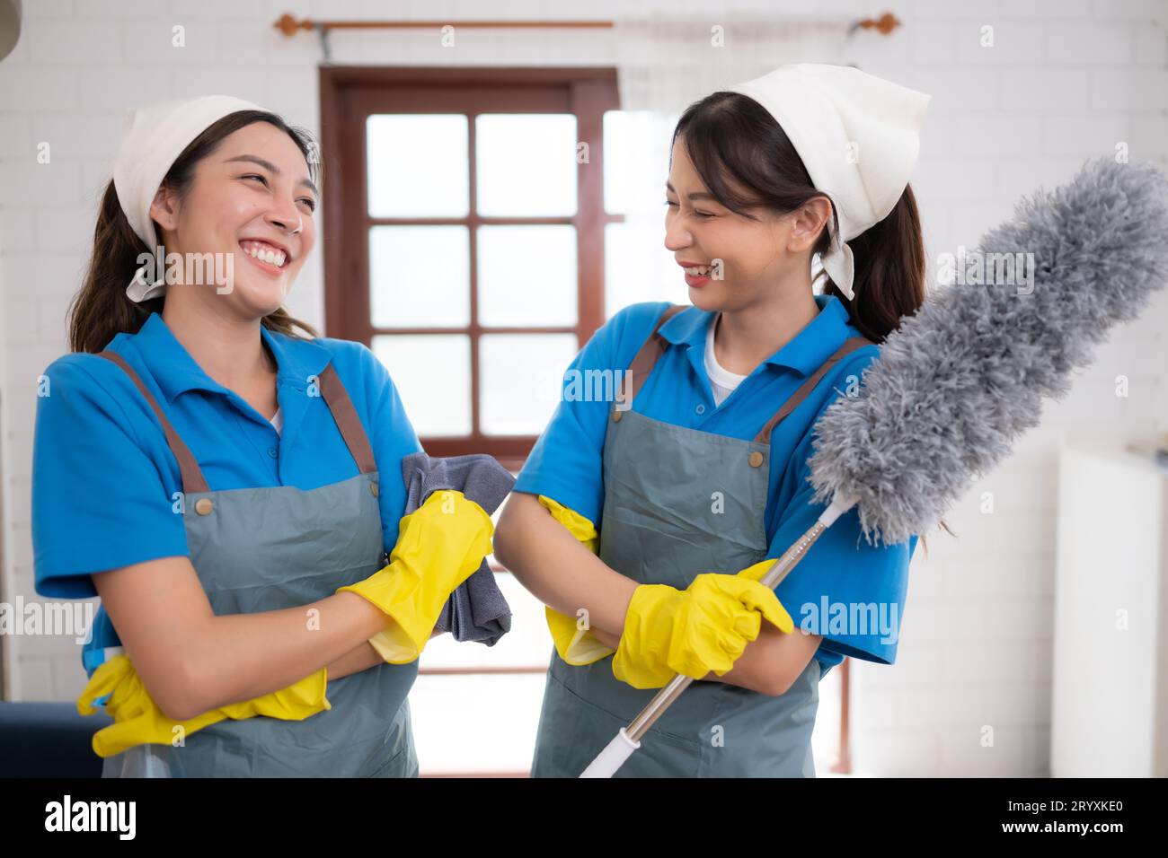 Portrait of asian female cleaning service staff in uniform and rubber ...