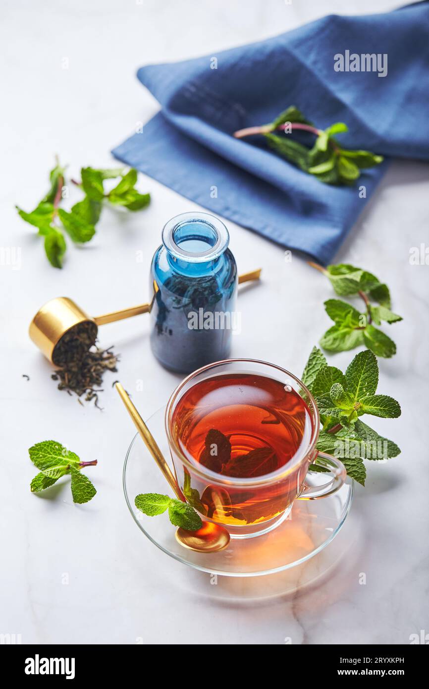 Black tea in glass transparent mug with mint leaves. Soothing tea, anti ...