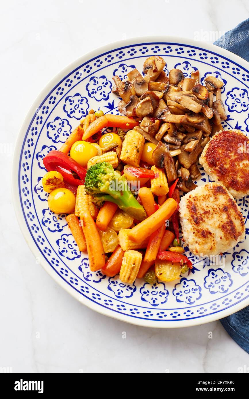 Plate with fried vegetables, carrots, broccoli, baby corn, bell peppers ...
