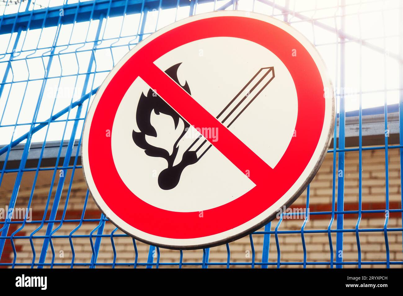 Sign prohibiting starting fire hangs on metal fence. Fire hazardous ...