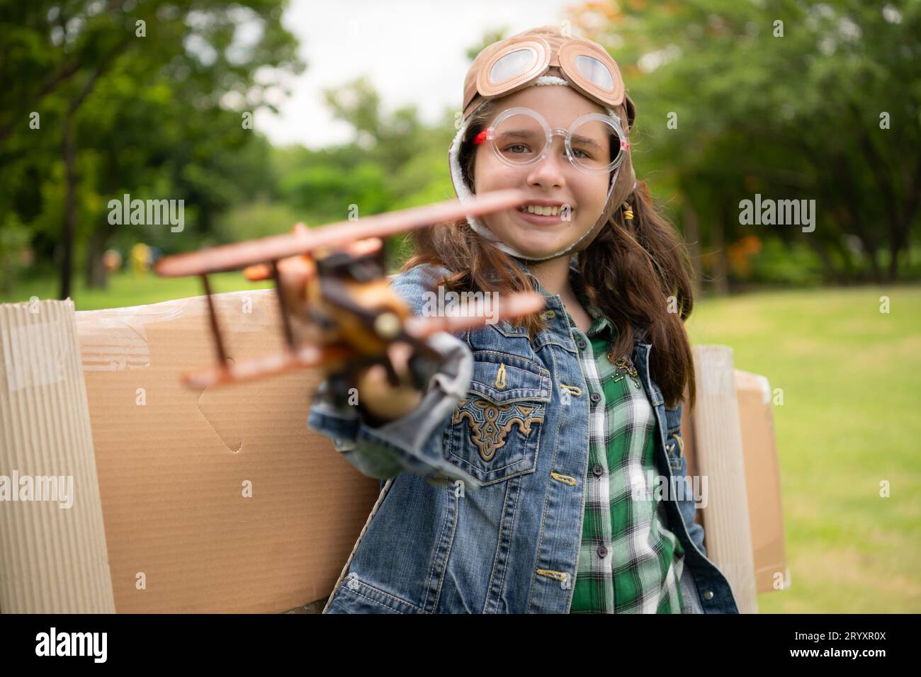 A little girl on vacation at the park with a pilot outfit and flying ...