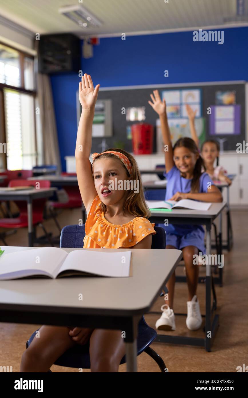 Primary school children raising hands in class hi-res stock photography ...