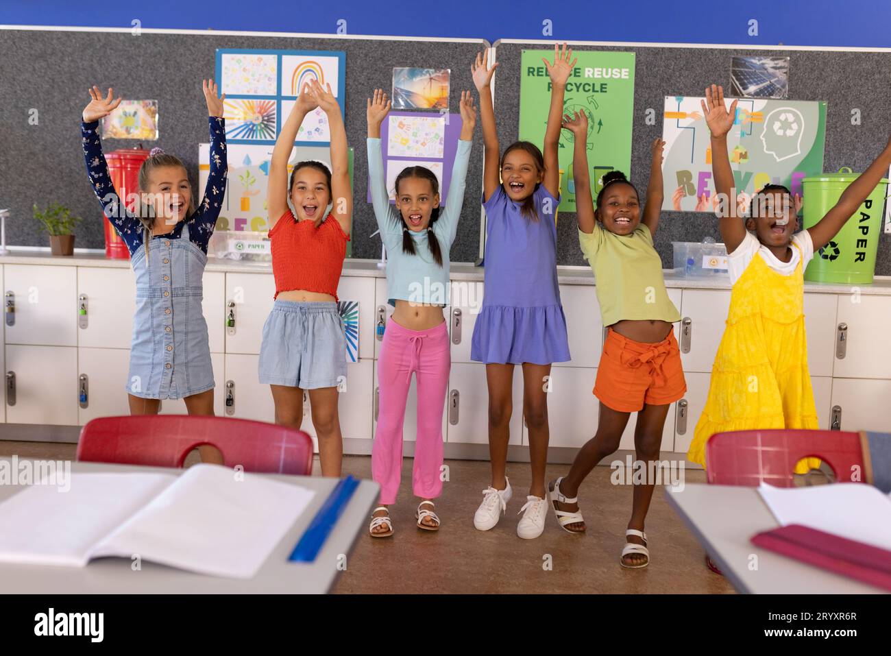 Portrait of happy diverse schoolgirls in elementary school classroom ...
