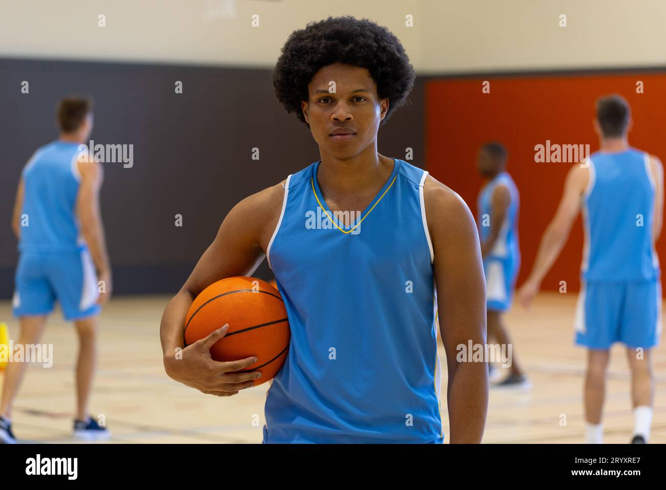 Portrait of biracial male basketball player wearing blue sports clothes ...