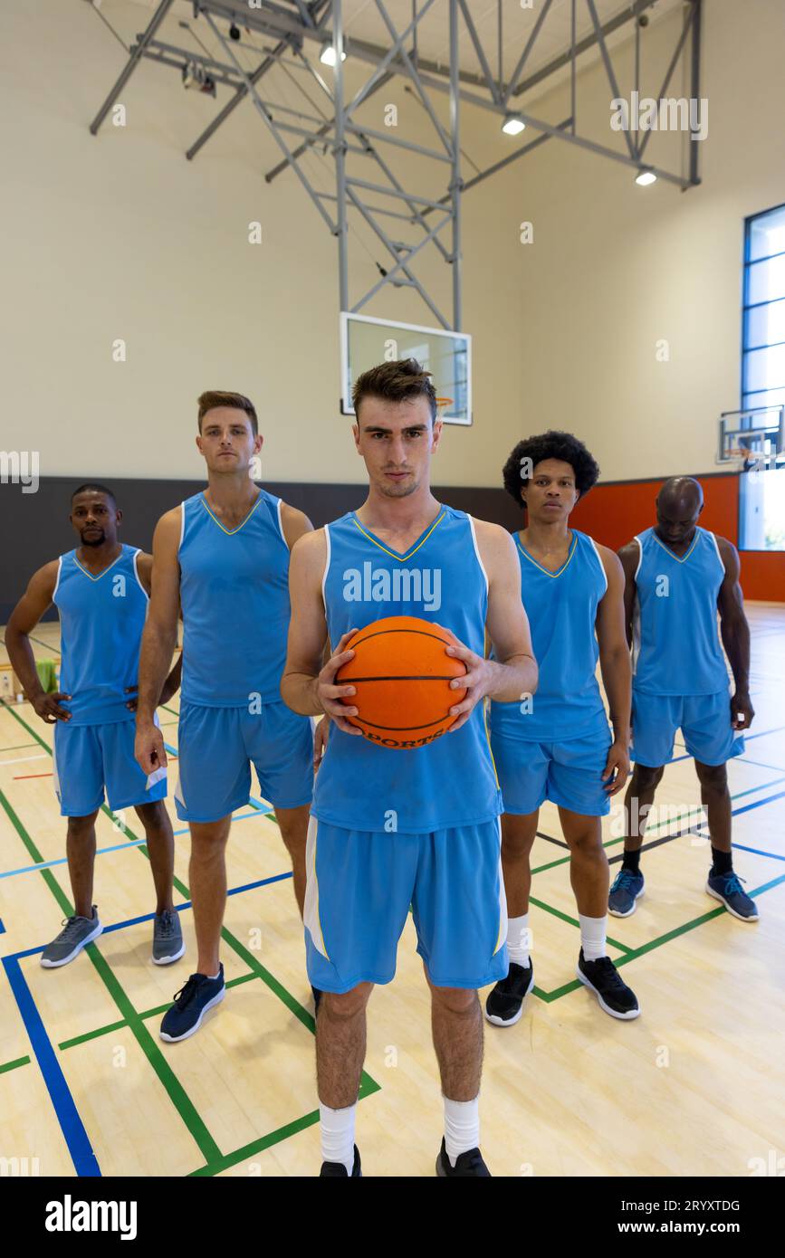 Portrait of serious diverse male basketball players wearing blue sports ...